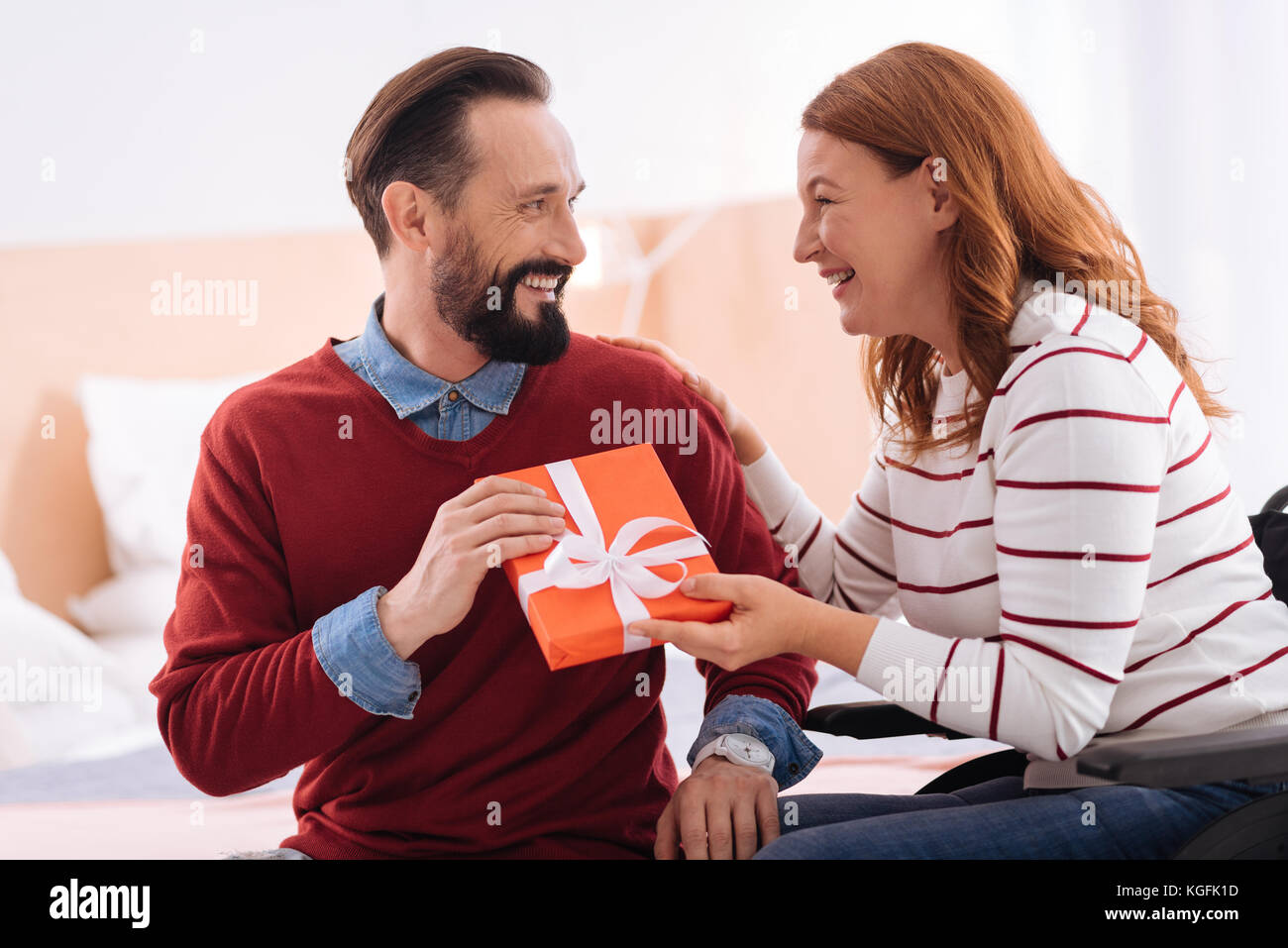 Cheerful woman receiving a gift from a beard man Stock Photo - Alamy