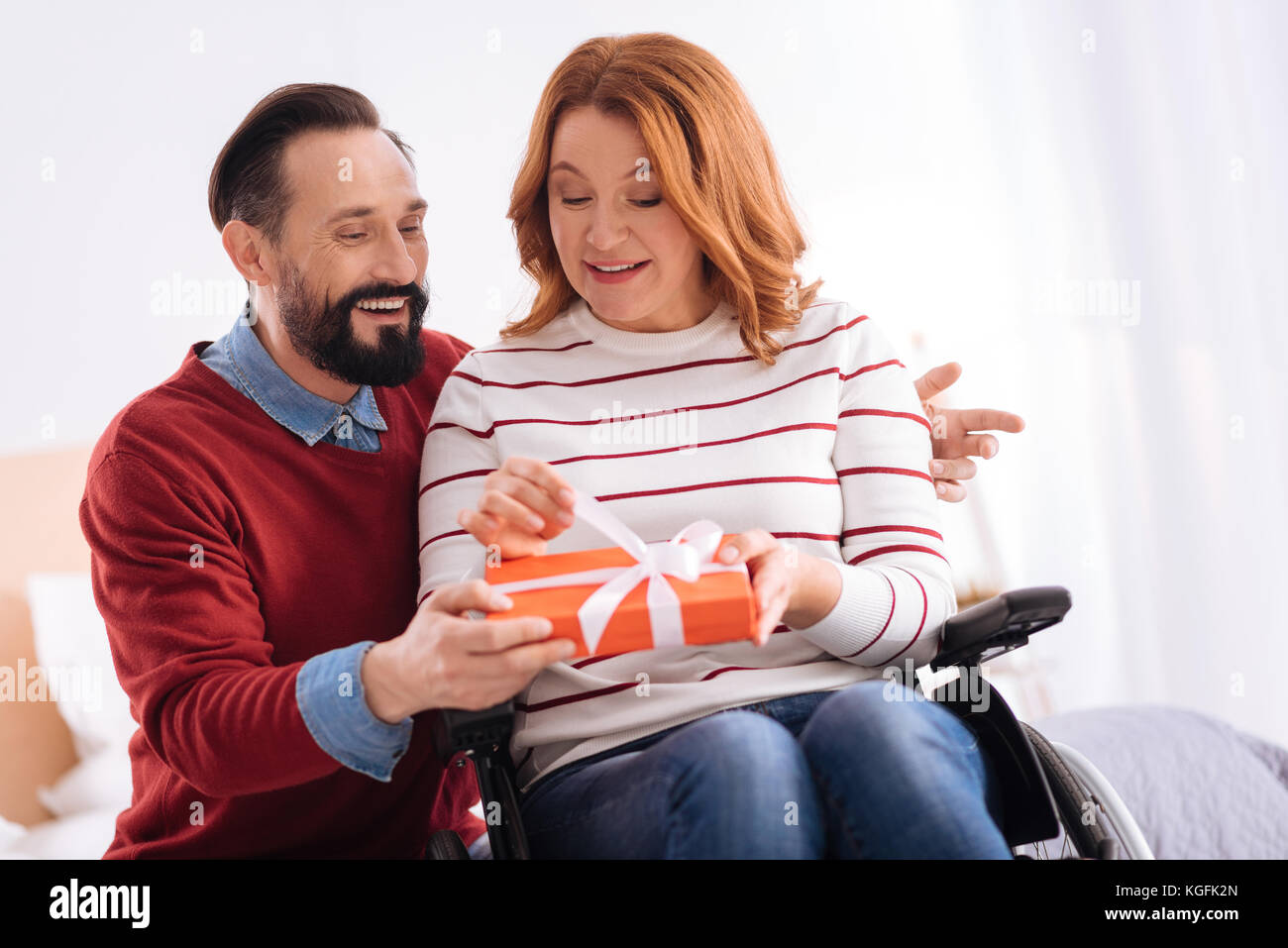 Smiling handicapped woman opening a gift Stock Photo - Alamy