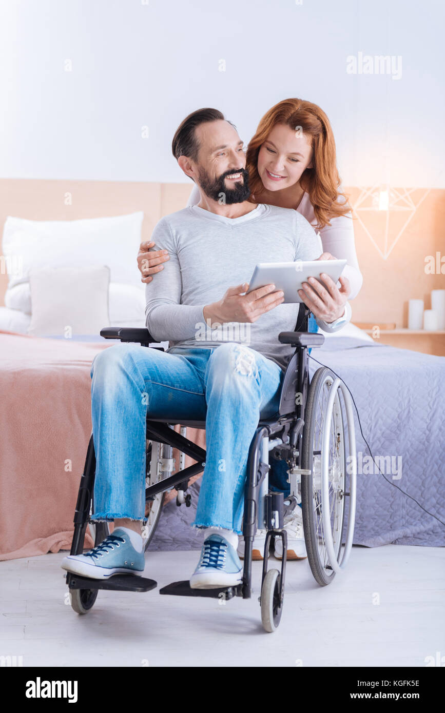 Cheerful woman hugging disabled man from behind Stock Photo - Alamy