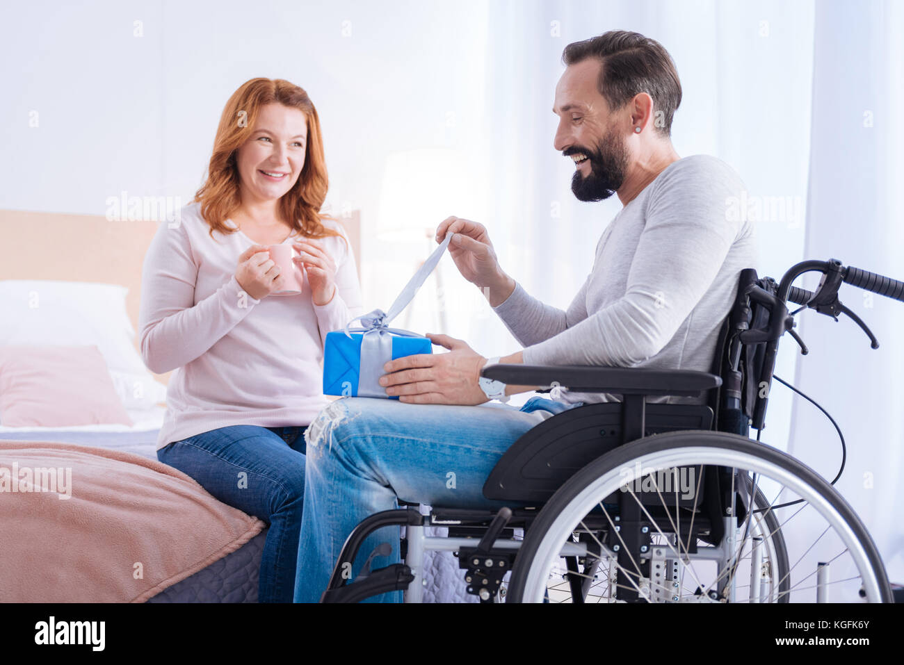 Happy handicapped man opening a gift Stock Photo - Alamy
