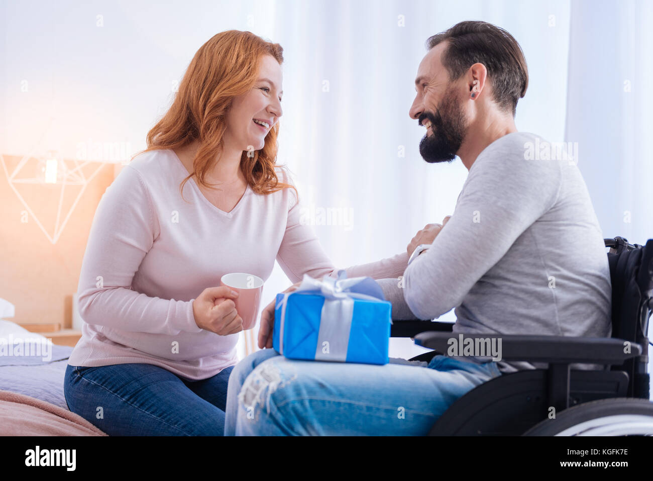Smiling woman giving a gift to a crippled man Stock Photo - Alamy