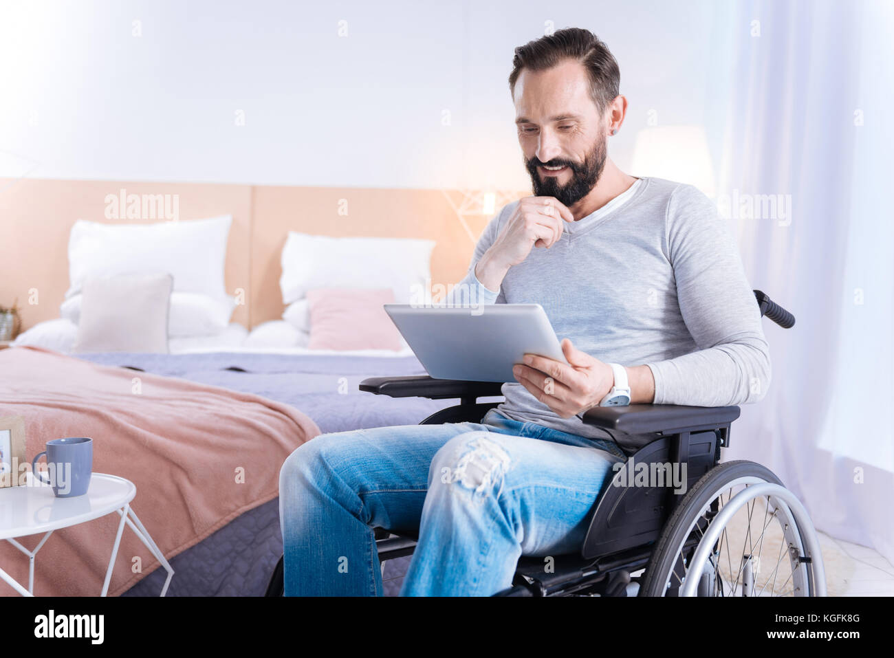 Happy disabled man using a tablet and smiling Stock Photo - Alamy