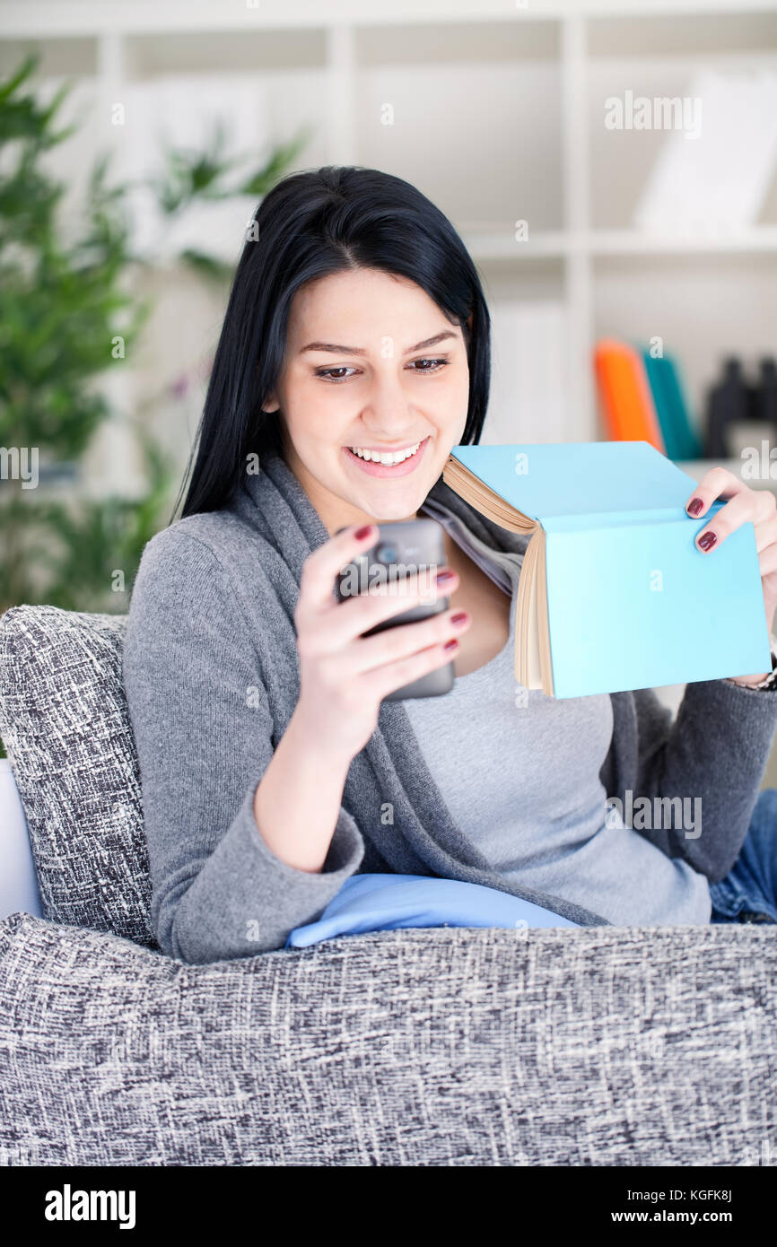 Young woman with book and mobile phone Stock Photo - Alamy