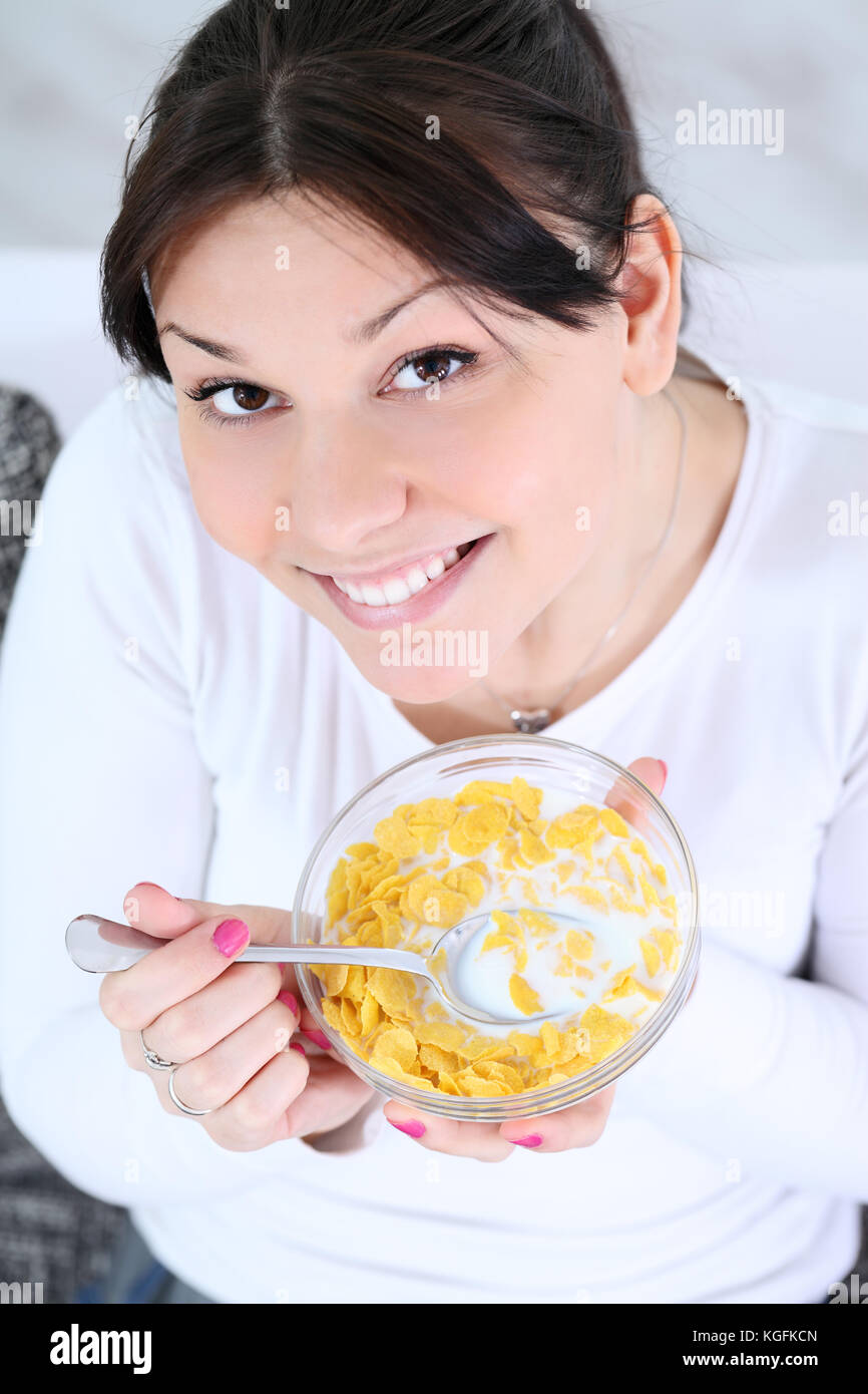 Young smiling woman eating cornflakes cereals, top view Stock Photo - Alamy