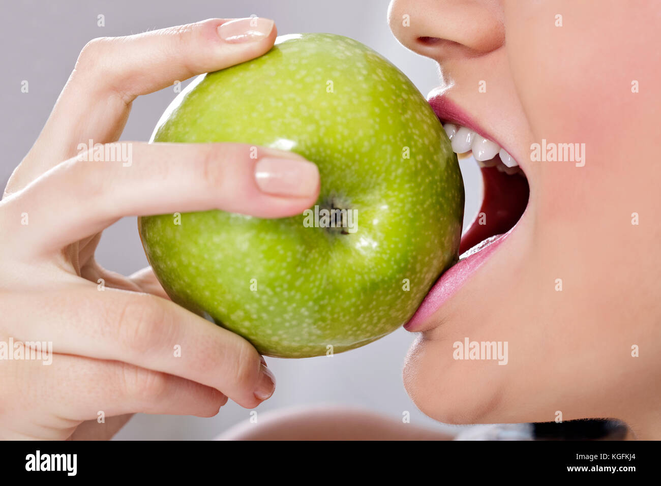 beautiful young woman biting a fresh green apple Stock Photo - Alamy