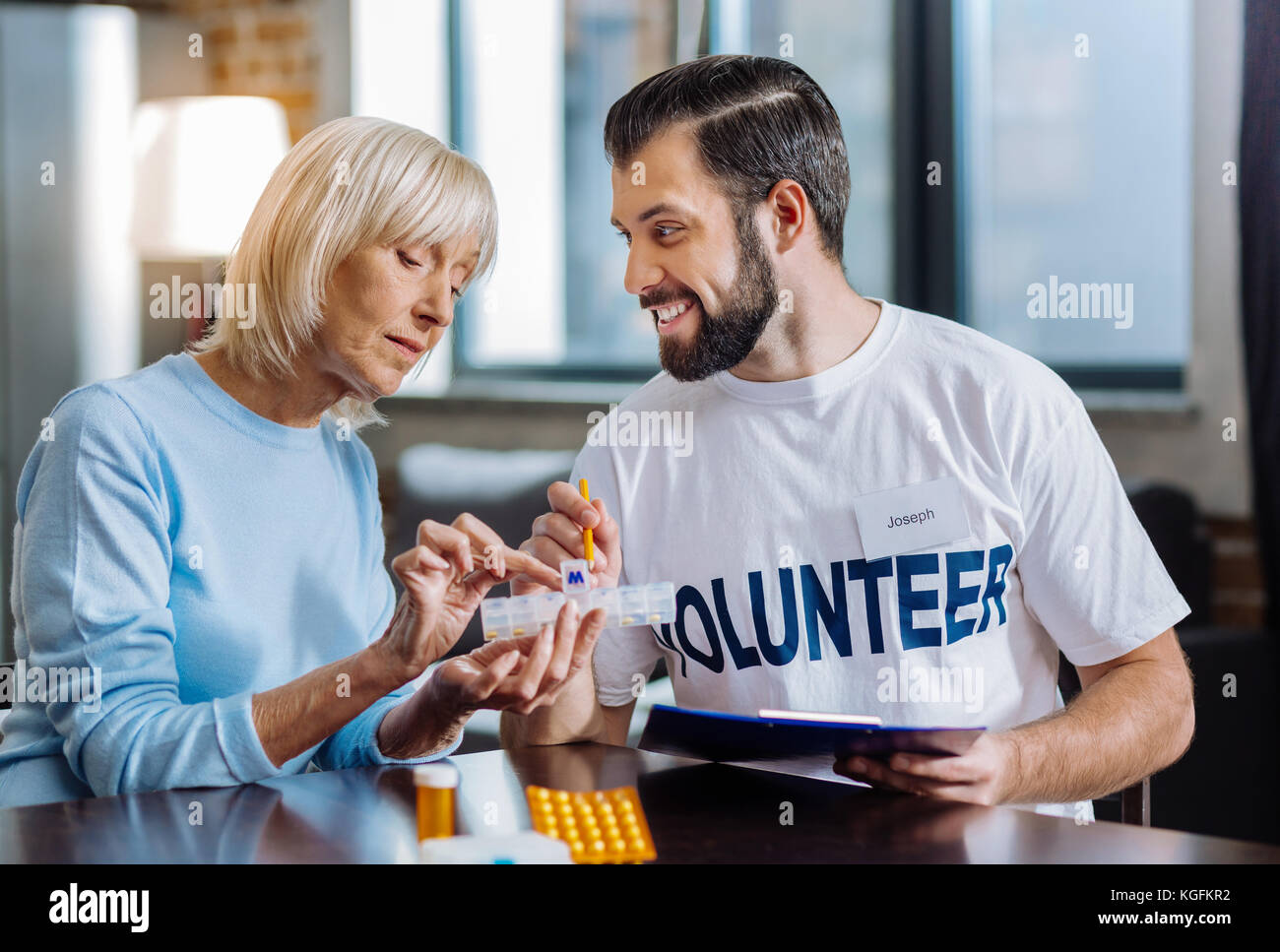 Concentrated senior woman using a convenient pill box Stock Photo - Alamy