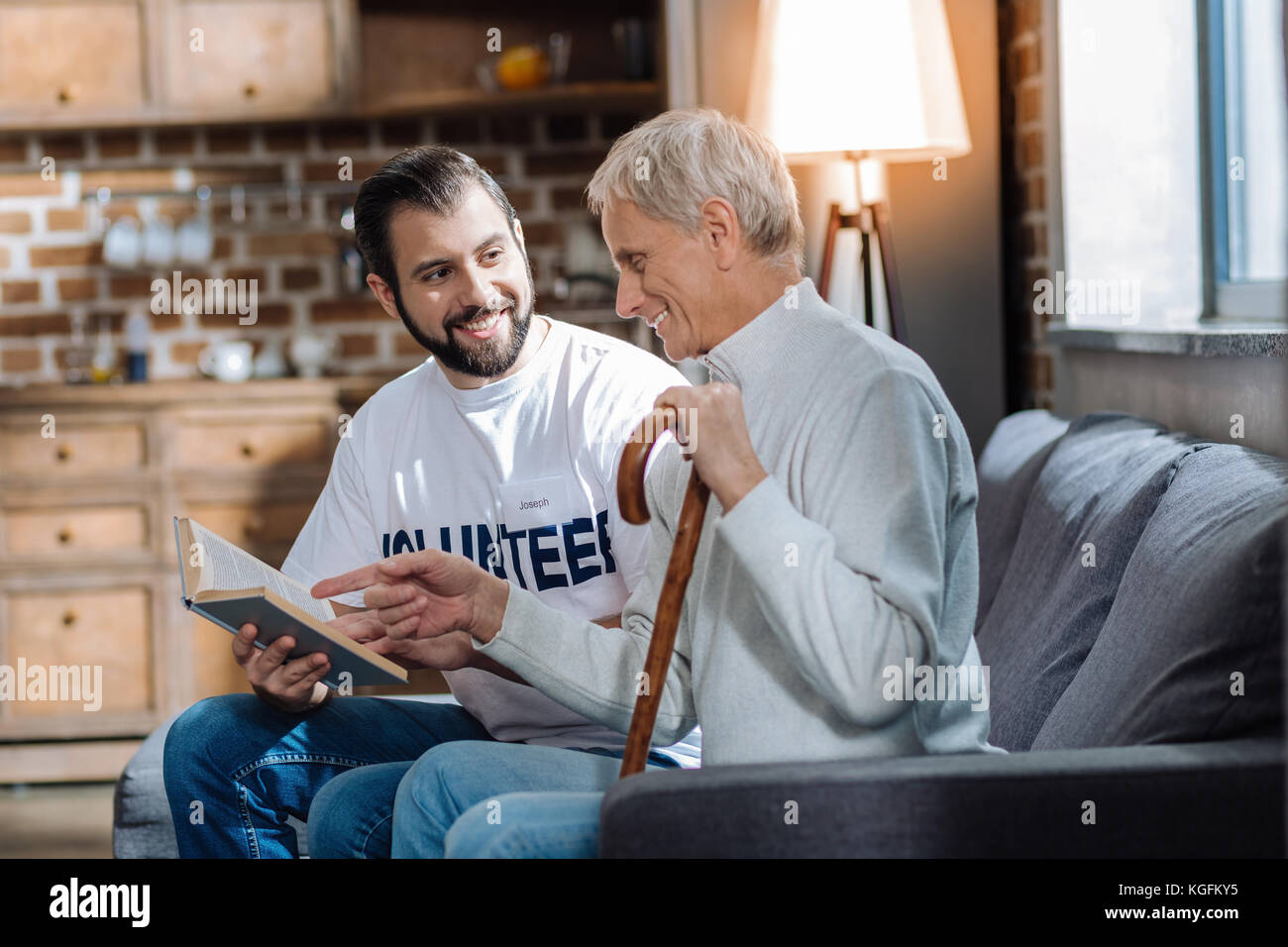 Cheerful pensioner pointing to the page of his favorite book Stock ...