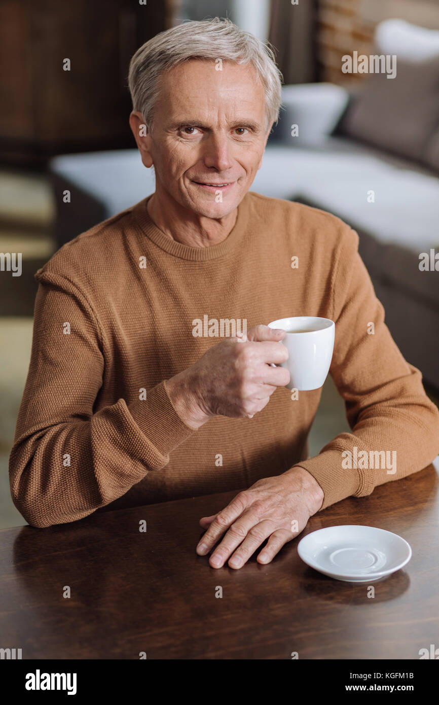 Handsome smiling pensioner drinking his favorite tea at home Stock ...