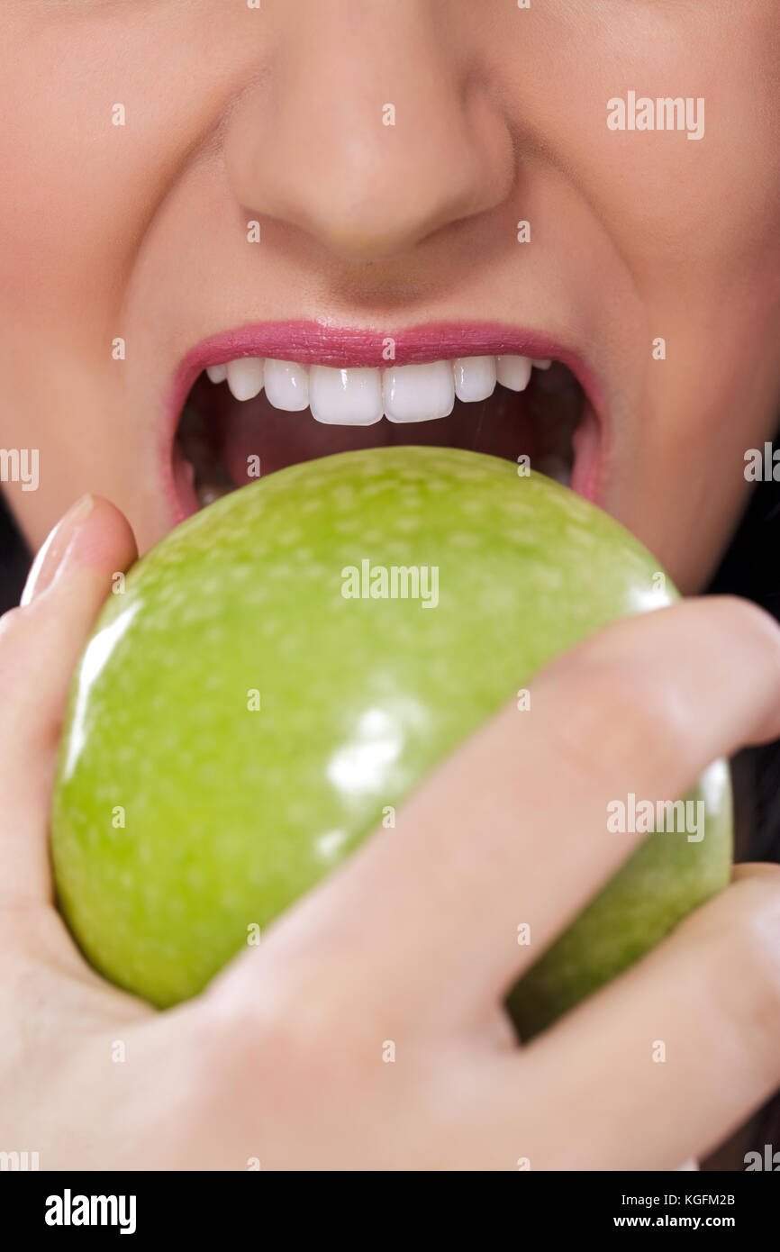 Woman biting green apple, close up Stock Photo - Alamy