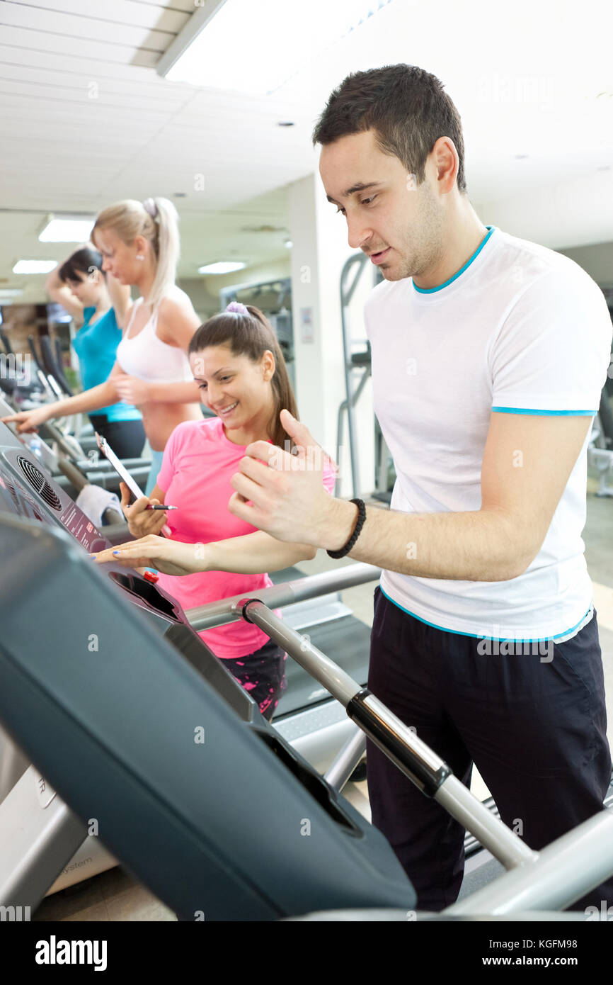 man using treadmill with personal trainer at gym Stock Photo - Alamy