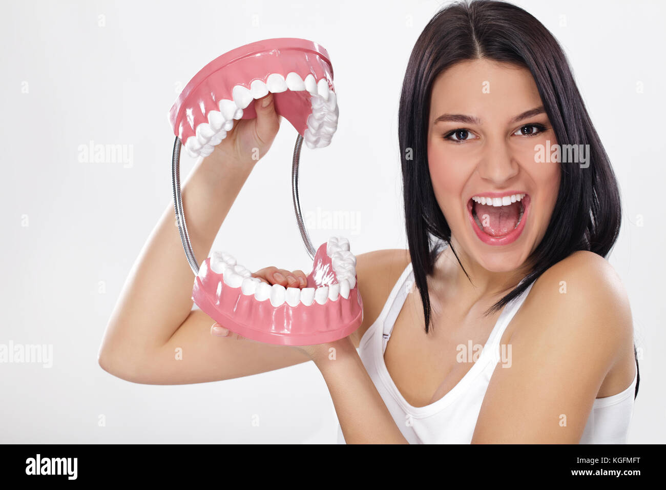 Funny woman holding open jaws, showing healthy teeth Stock Photo - Alamy