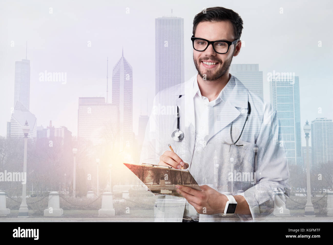 Cheerful young doctor smiling while making notes Stock Photo - Alamy