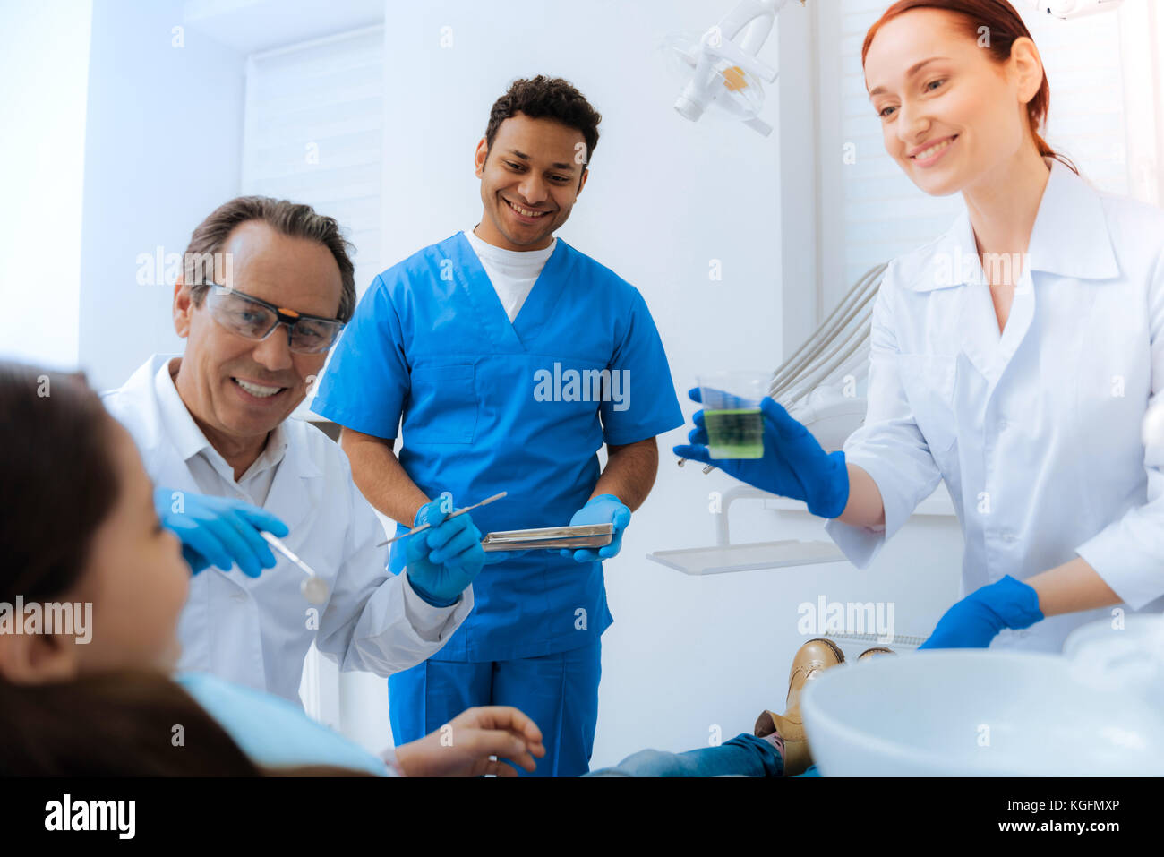 Professional nice doctors looking a their young patient Stock Photo - Alamy