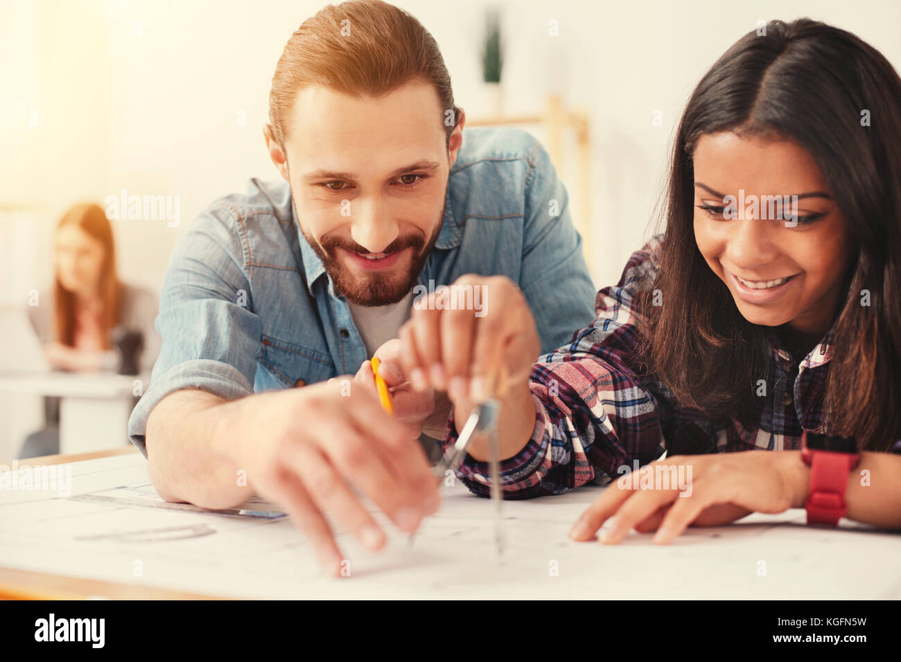 Two young people measuring the distance on a scheme Stock Photo - Alamy