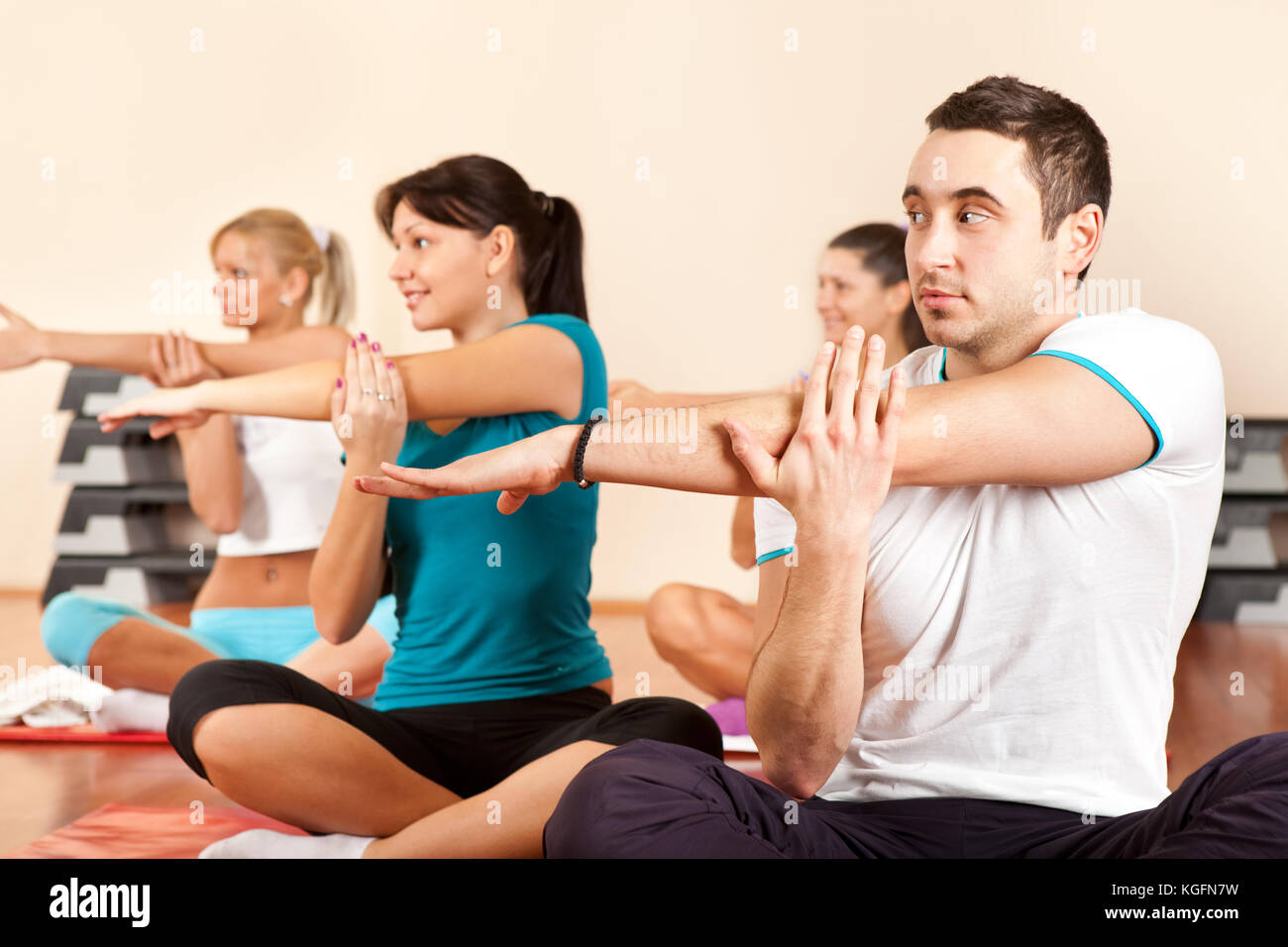 Group of gym people stretching at a gym Stock Photo - Alamy