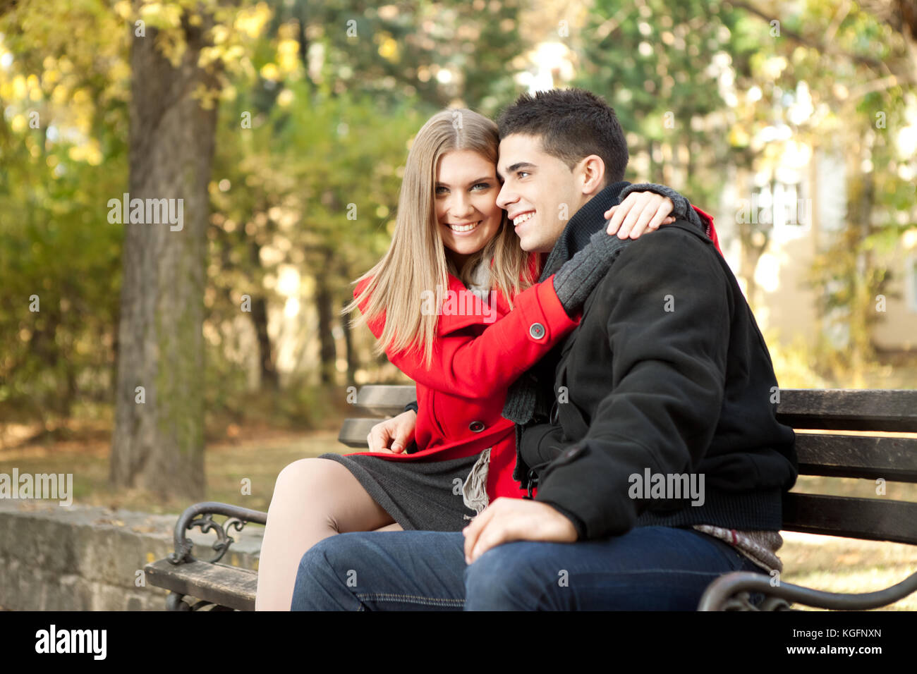 young affectionate couple hugging on bench in park Stock Photo - Alamy