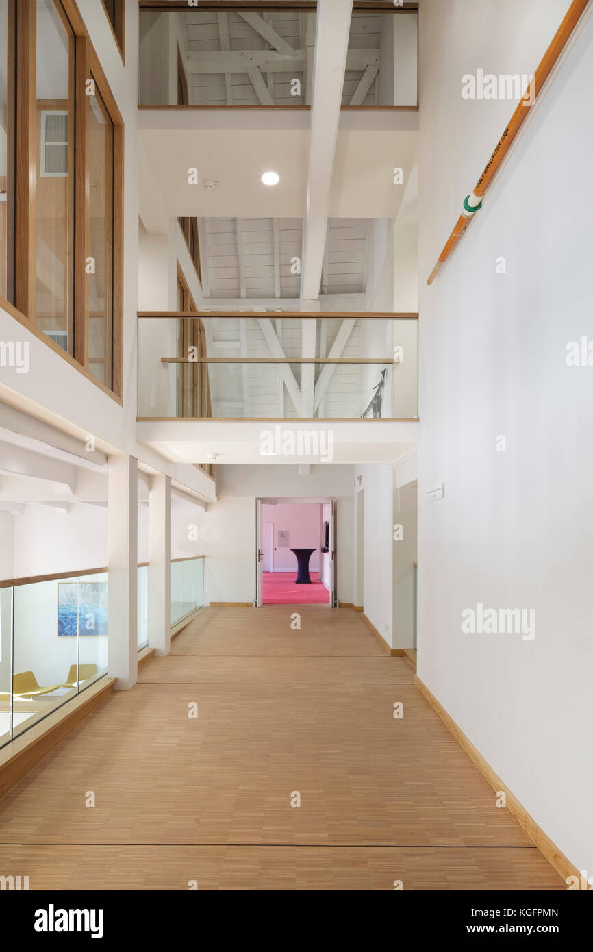 Restored corridor leading towards original building with exposed white ...
