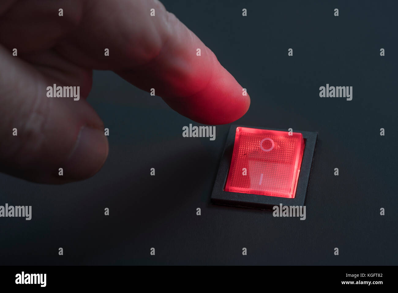 Finger hovering over illuminated red electrical switch - potential ...