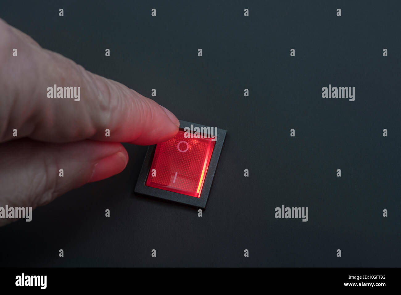 Finger hovering over illuminated red electrical switch - potential ...