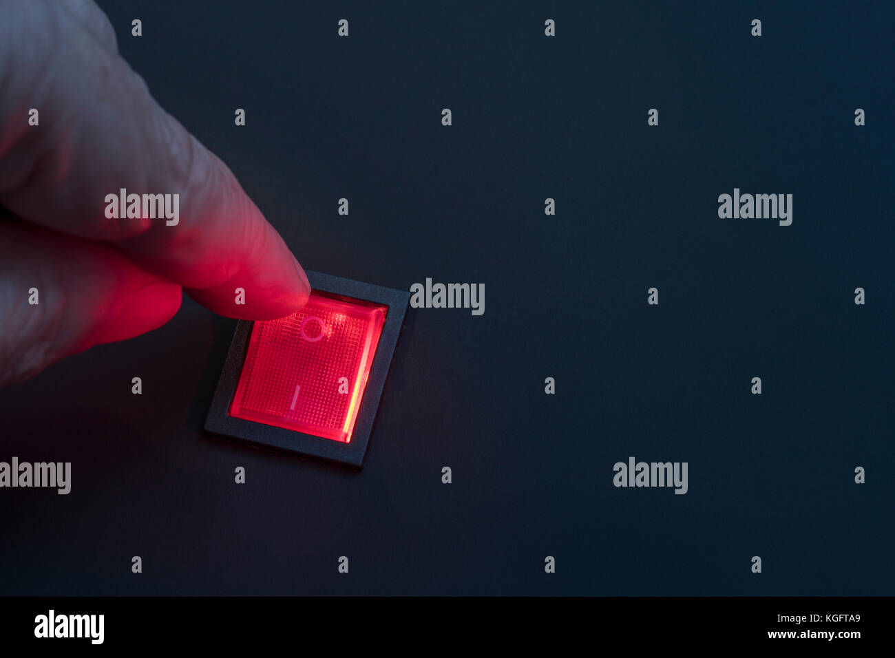 Finger hovering over illuminated red electrical switch - potential ...