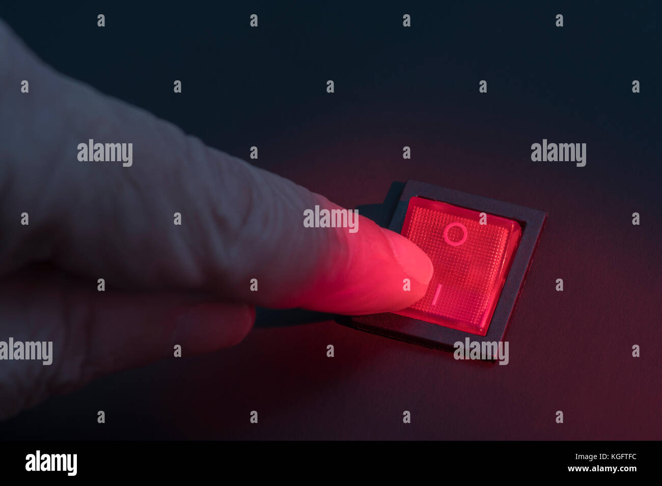 Finger hovering over illuminated red electrical switch - potential ...