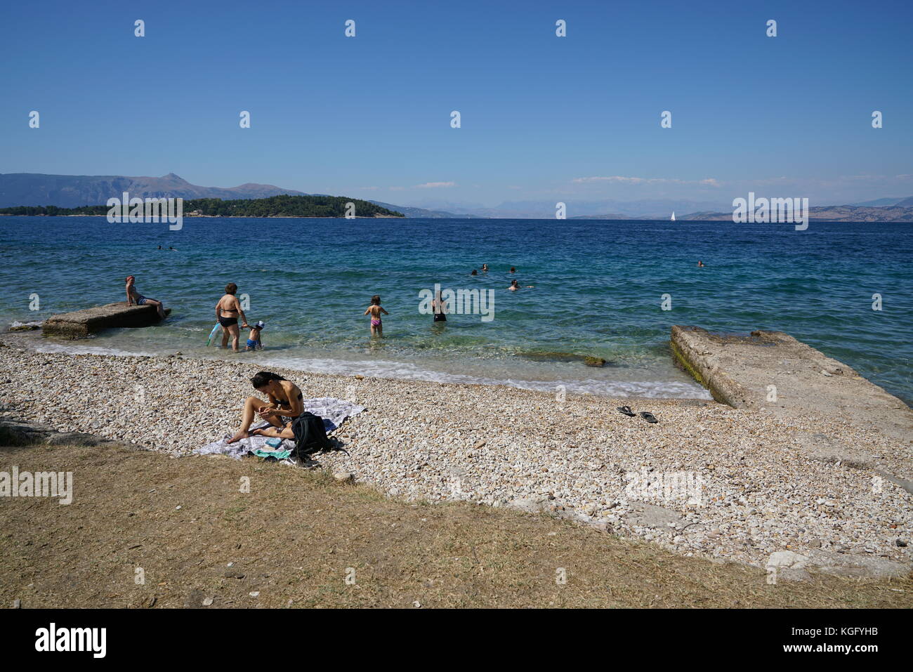 Corfu, Greece: People at the beach swimming and sunbathing Stock Photo ...