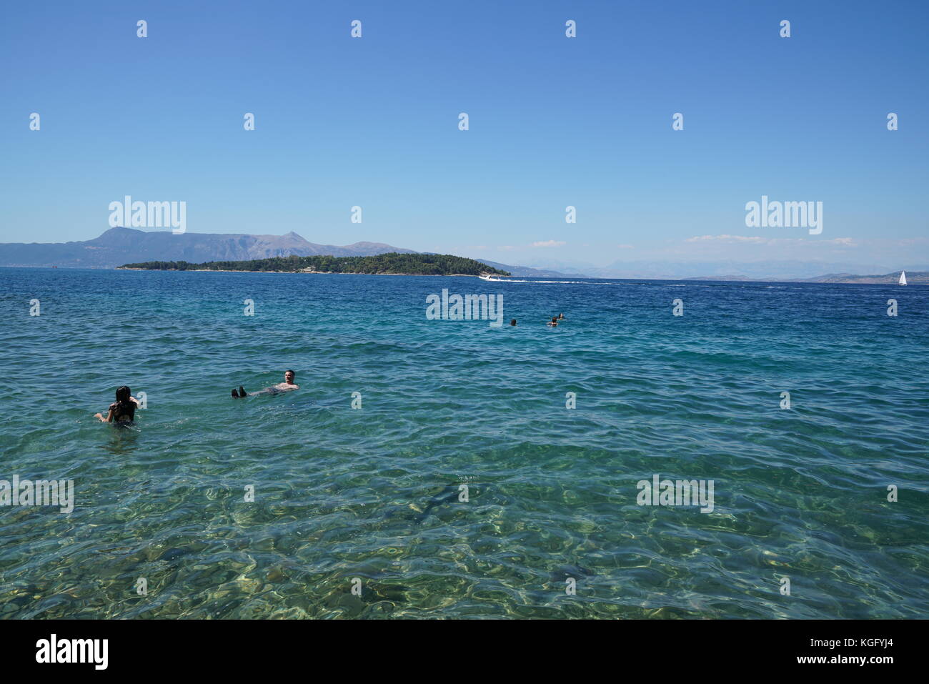 Corfu, Greece: People at the beach swimming and sunbathing Stock Photo ...