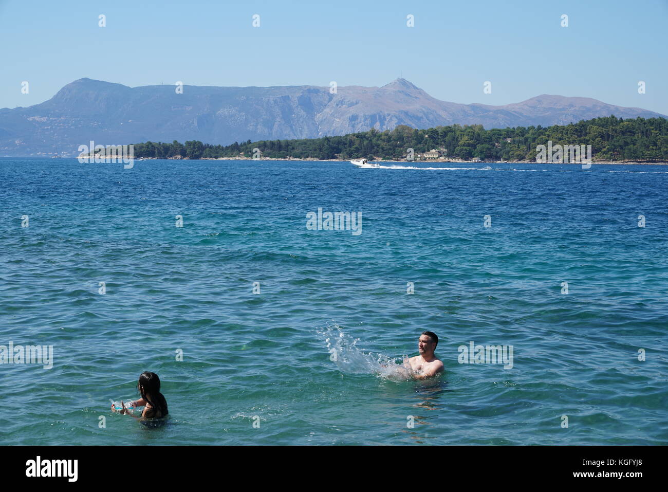 Corfu, Greece: People at the beach swimming and sunbathing Stock Photo ...