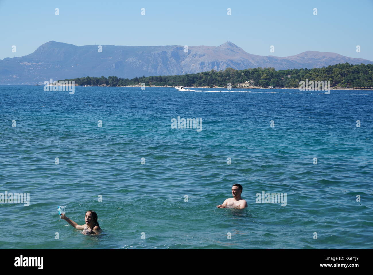 Corfu, Greece: People at the beach swimming and sunbathing Stock Photo ...