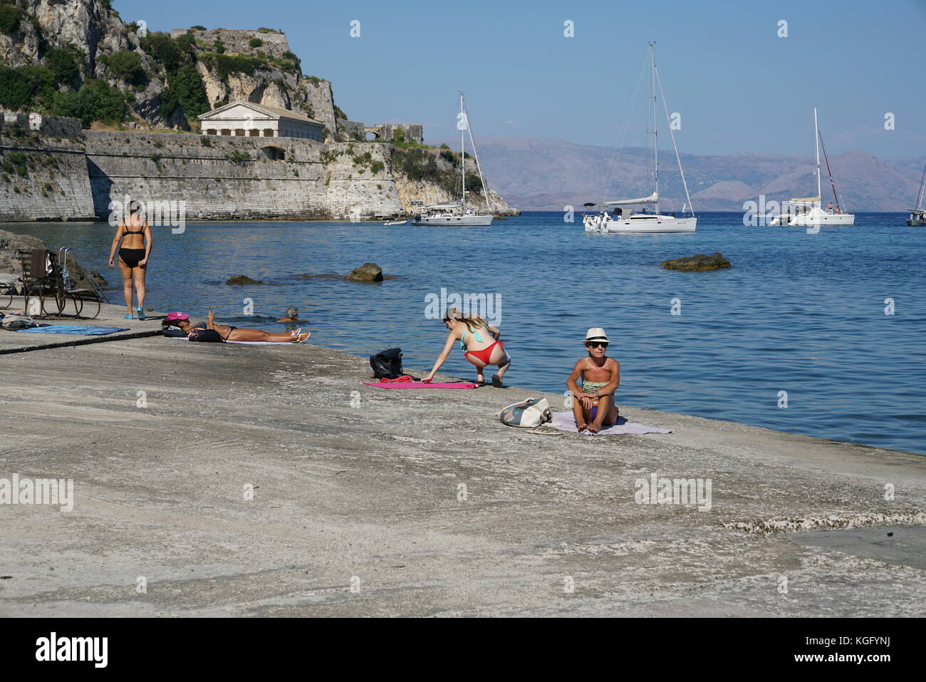 Corfu, Greece: People at the beach swimming and sunbathing Stock Photo ...