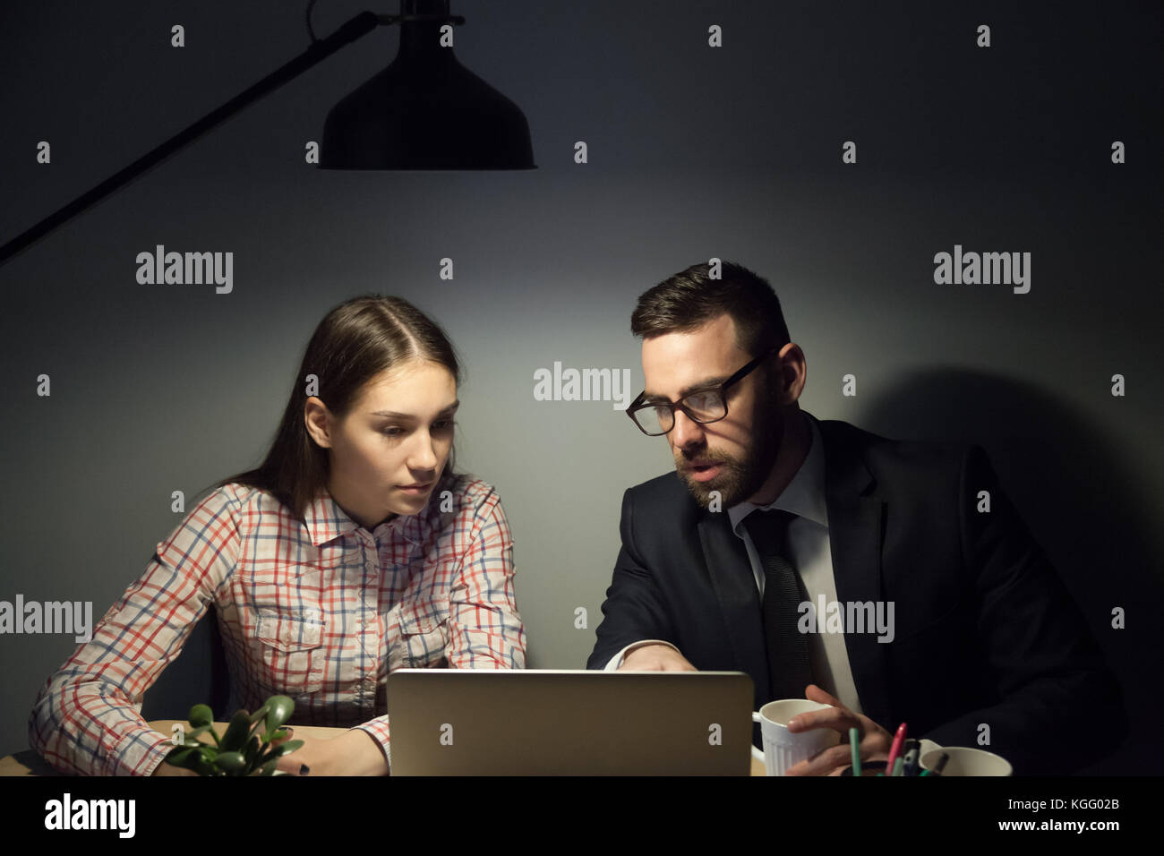 Late evening study session in corporate office. Male professional coach ...