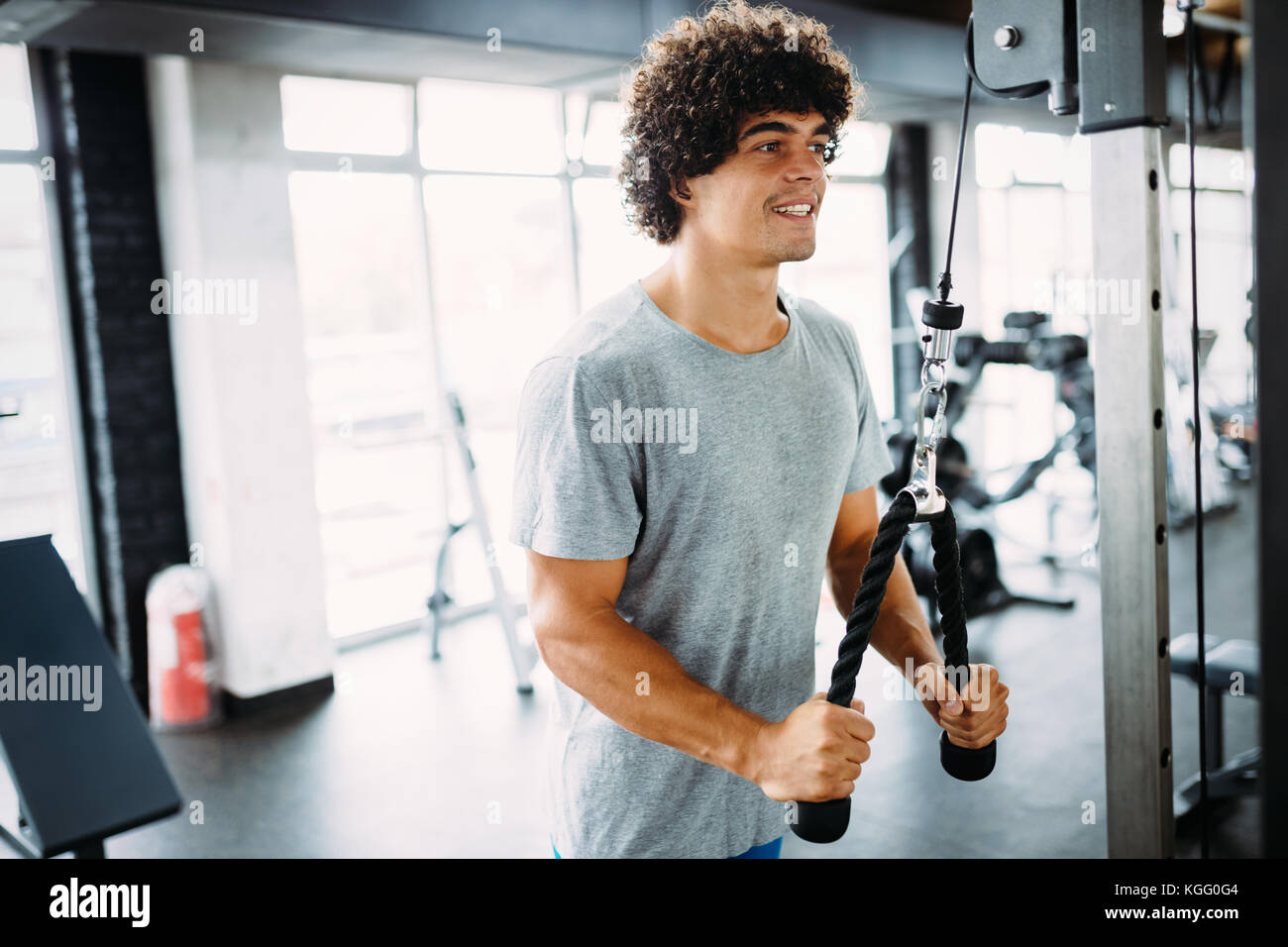 Young handsome man doing exercises in gym Stock Photo - Alamy