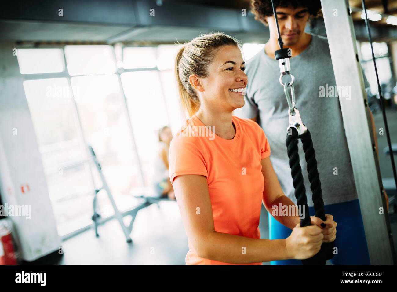 Young beautiful woman doing exercises with personal trainer Stock Photo ...