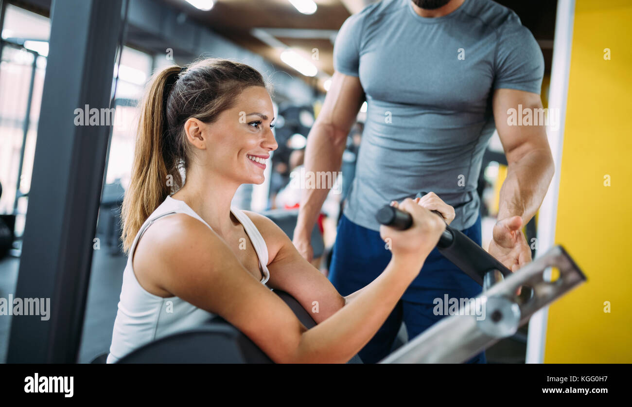Young beautiful woman doing exercises with personal trainer Stock Photo ...