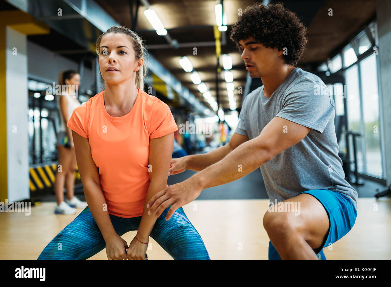 Young beautiful woman doing exercises with personal trainer Stock Photo ...