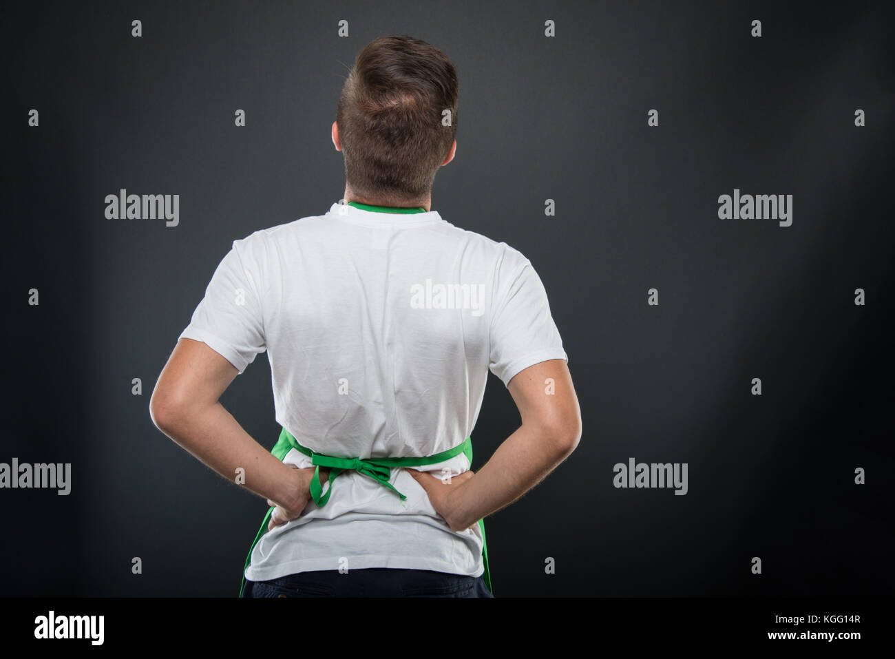 Back view of supermarket employer holding back like hurting on black ...