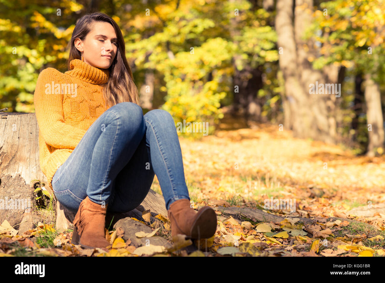 Woman relaxing outside in colorful fall forest enjoying her free time ...