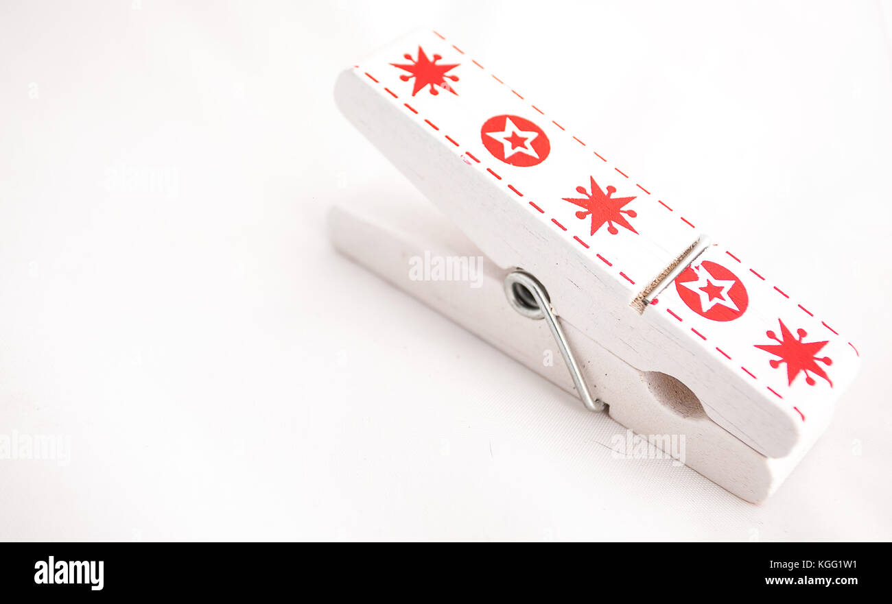 White and red wooden decorated pegs on a white background in studio ...