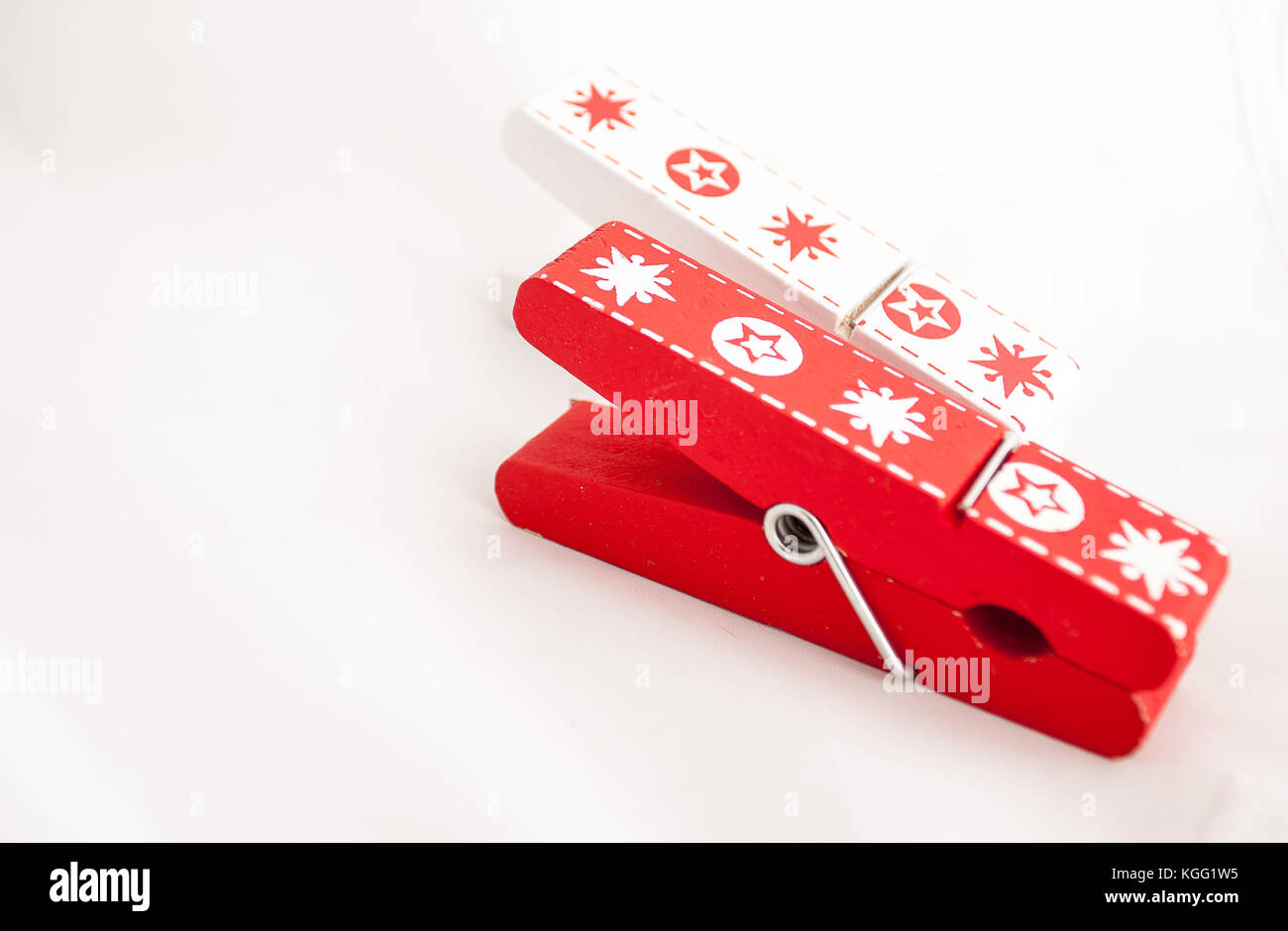 White and red wooden decorated pegs on a white background in studio ...