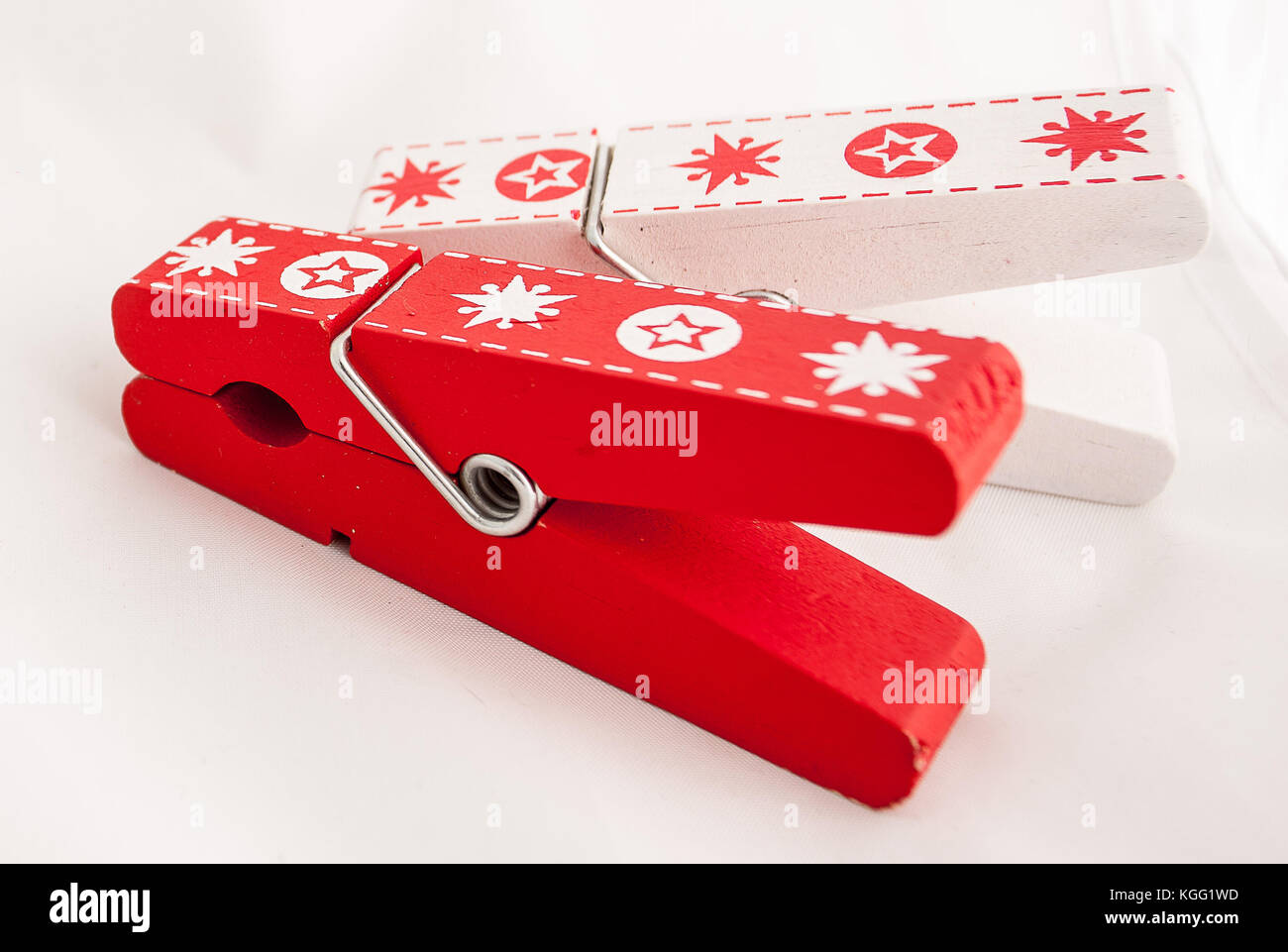 White and red wooden decorated pegs on a white background in studio ...