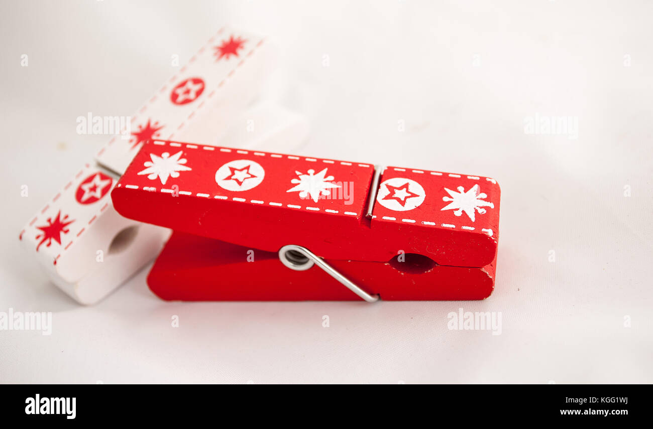 White and red wooden decorated pegs on a white background in studio ...
