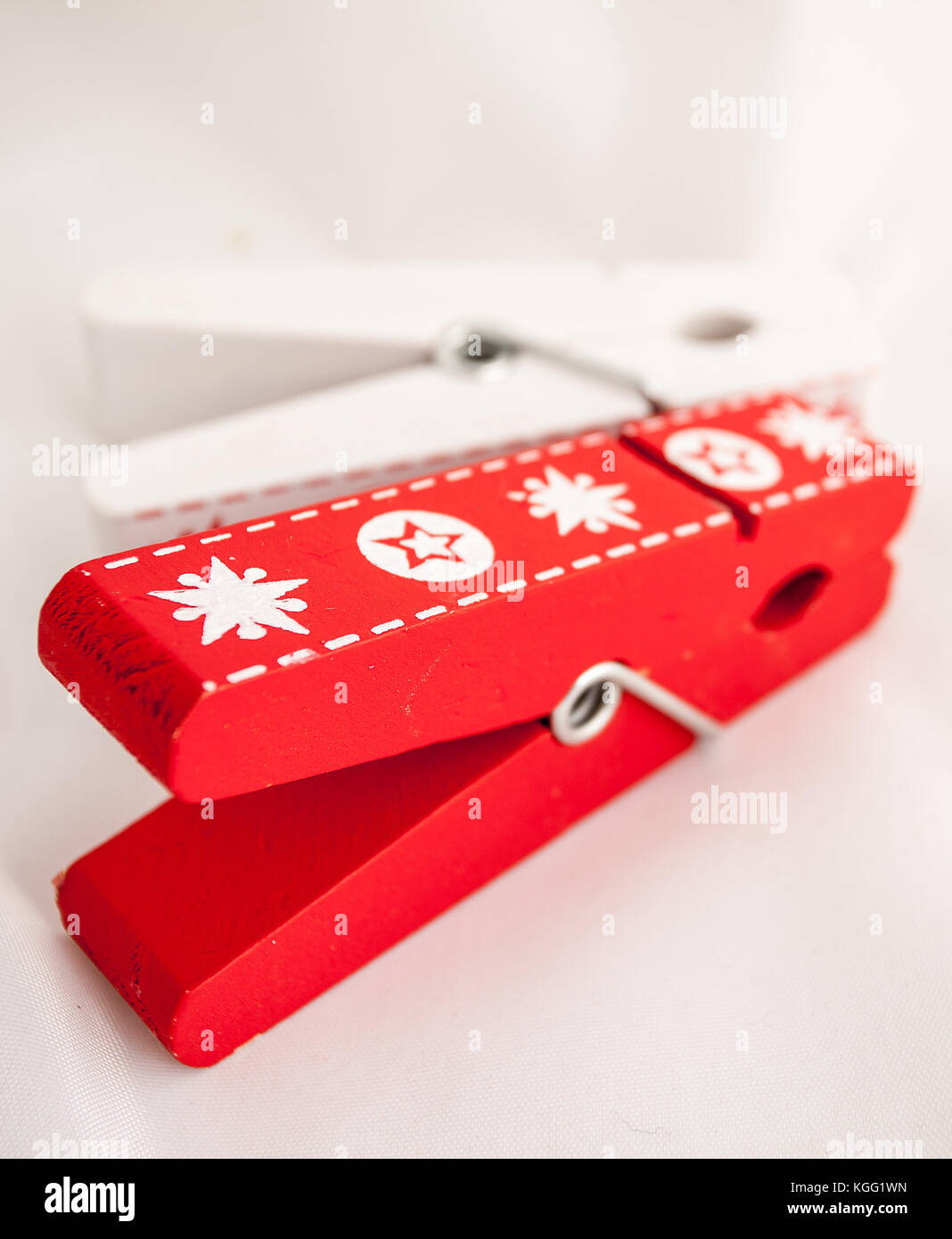White and red wooden decorated pegs on a white background in studio ...