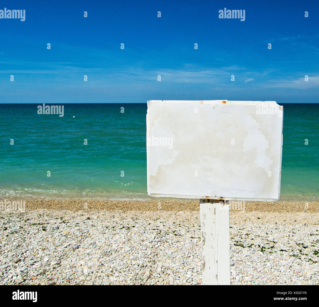 white advice panel on a beach with ocean on the background. for ...