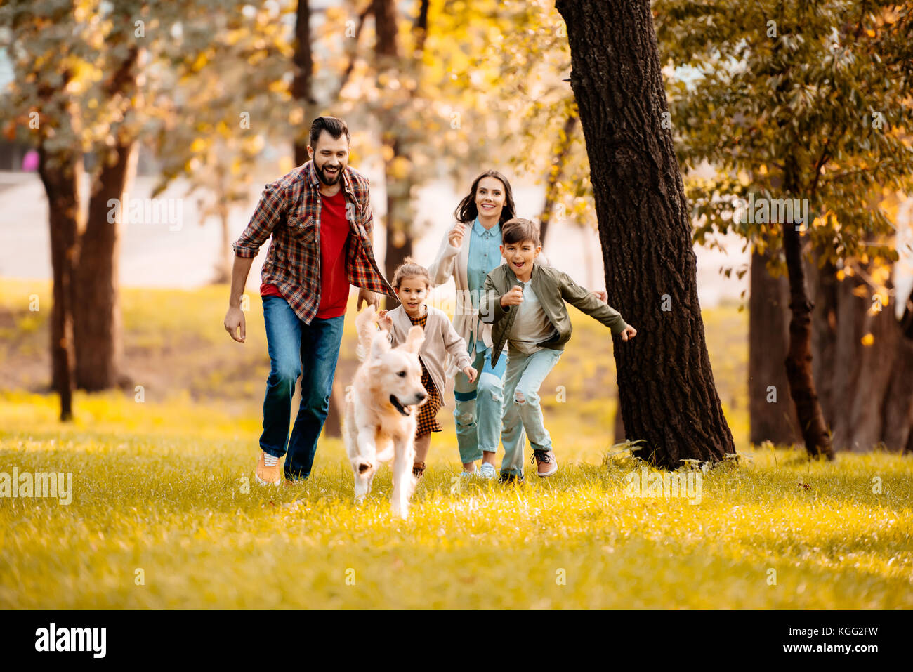 family running after dog Stock Photo - Alamy
