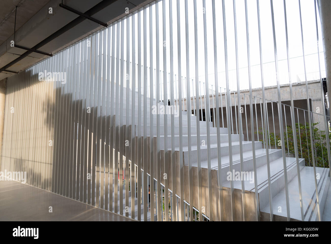 Light and shadows of white iron bar projected onto the white stairway ...