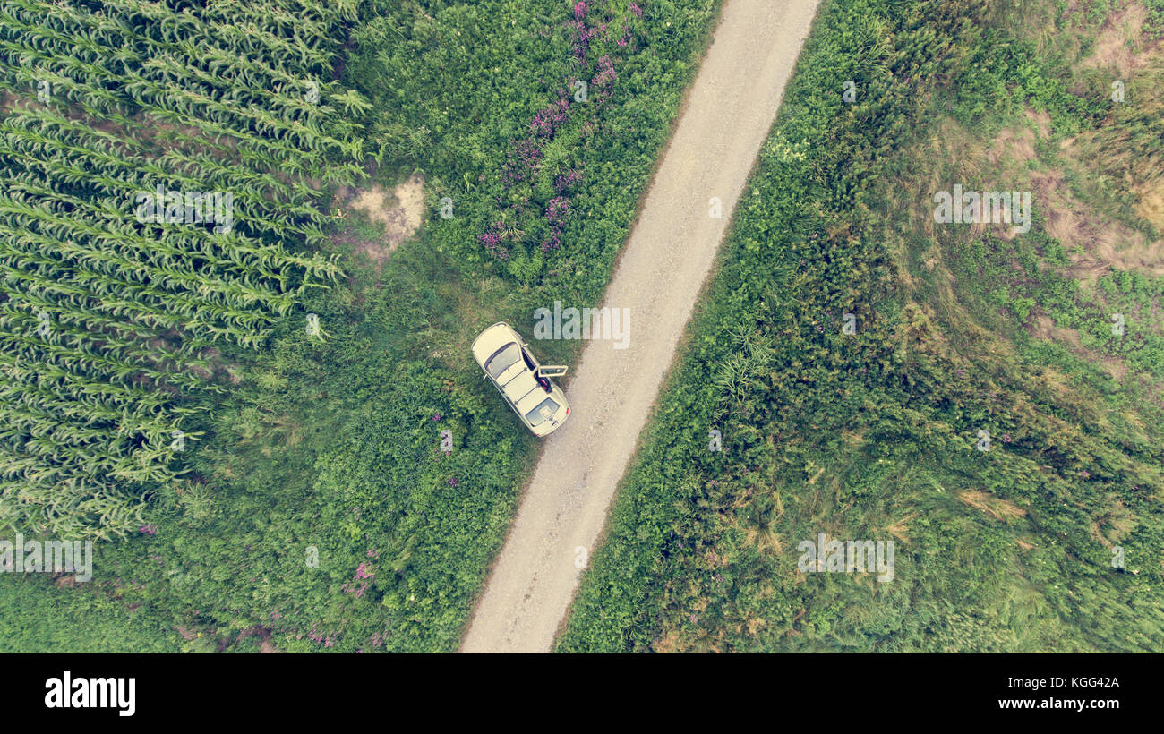 Drop down view of a car parked along field road Stock Photo - Alamy