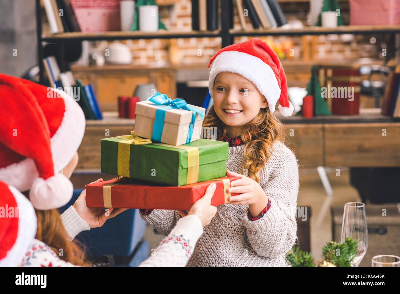 girl giving stack of presents to mother Stock Photo - Alamy