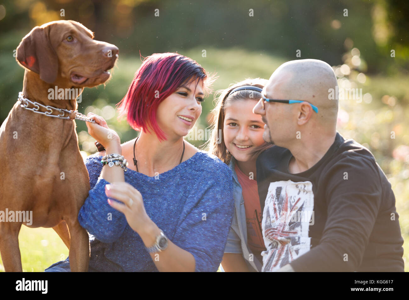 Amazing family of three playing in the park with their dog Stock Photo ...