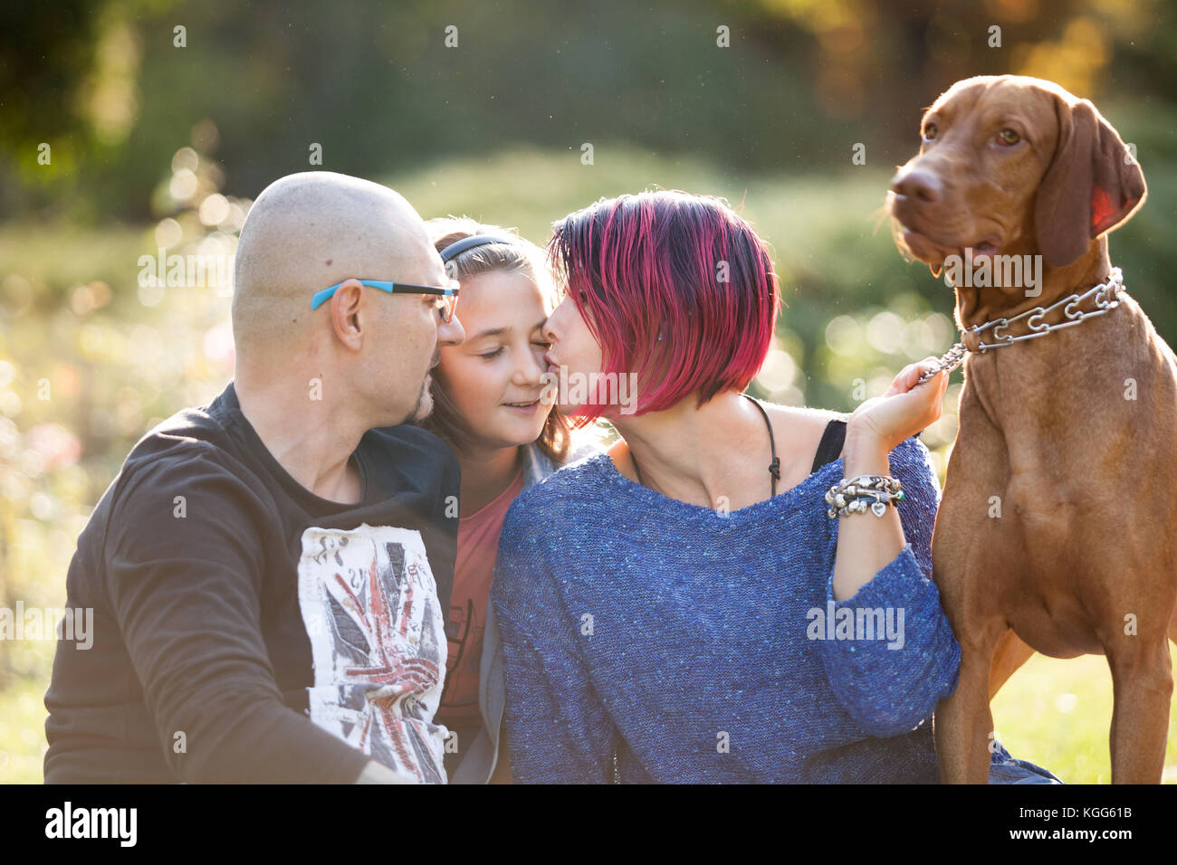 Amazing family of three playing in the park with their dog Stock Photo ...