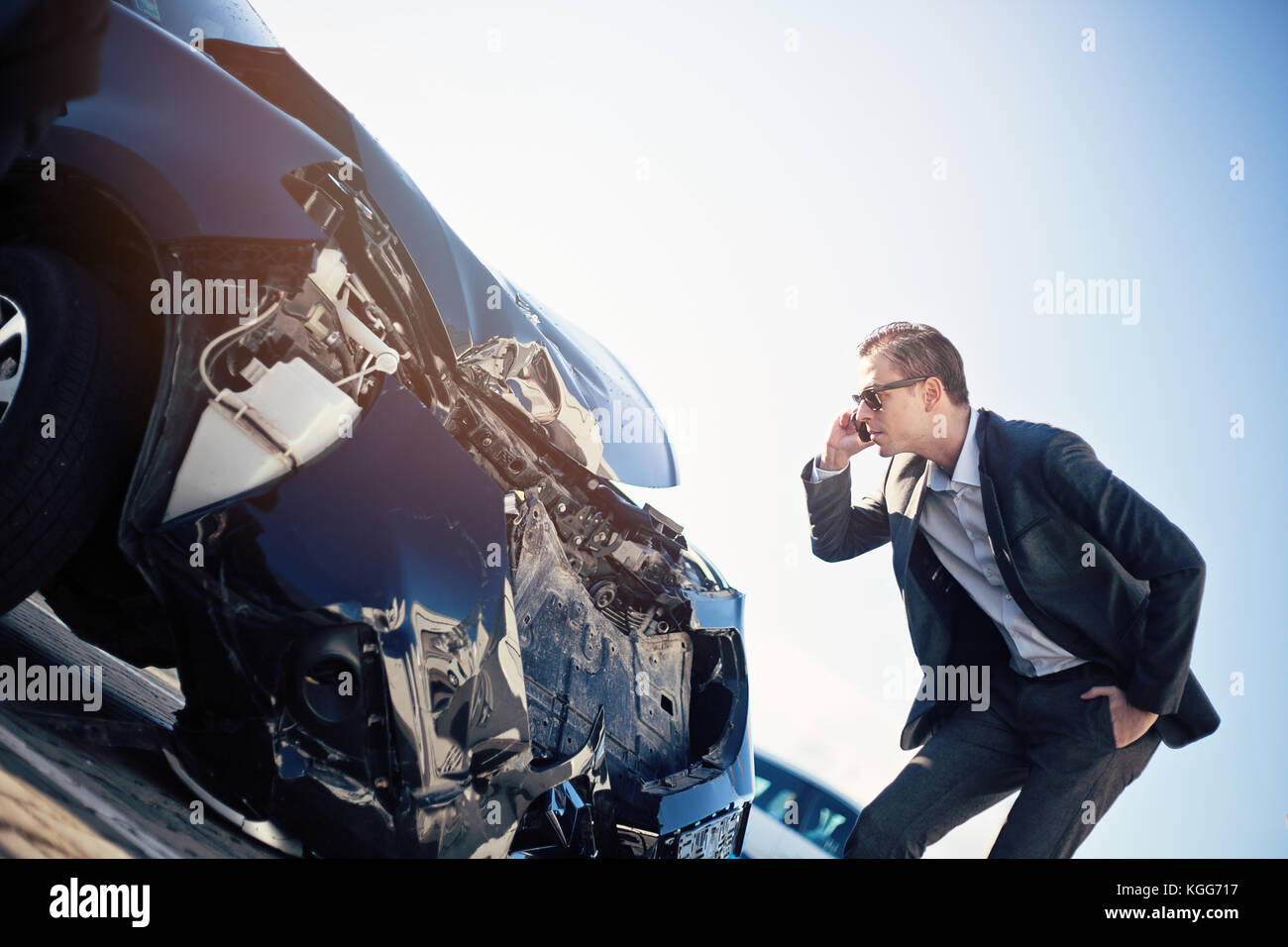 Male adult man in a black winter coat and sunglasses checking damaged ...